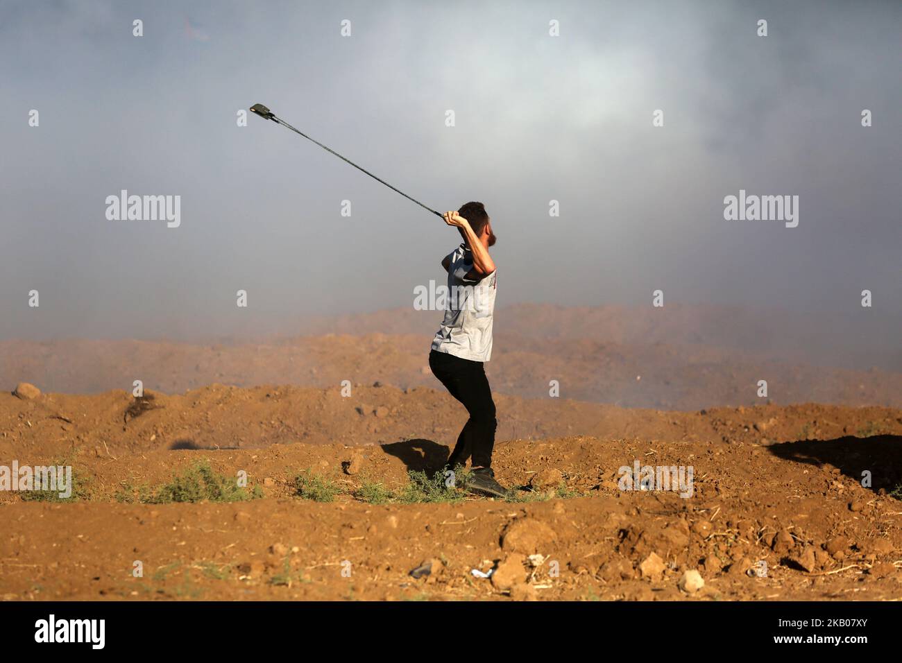 A Palestinian protester uses a slingshot during a demonstration along ...