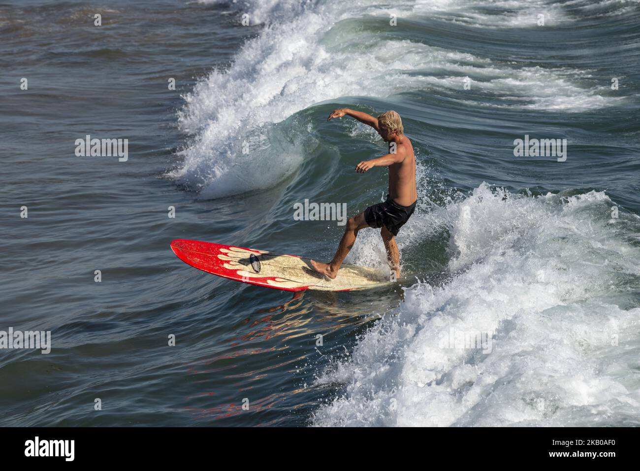 A surfer rides a wave in the Pacific Ocean near Venice Beach in Los ...