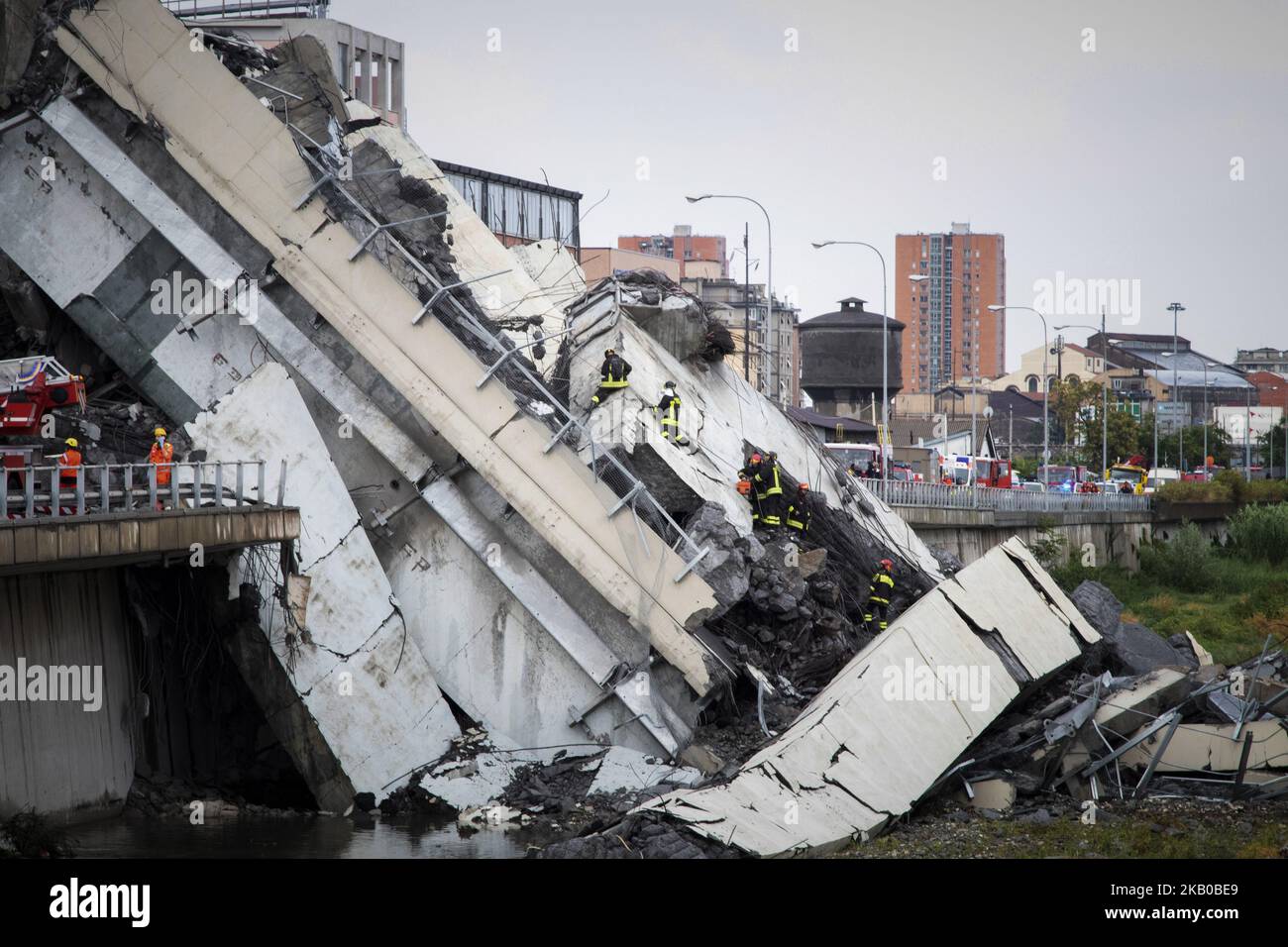 A picture taken on August 14, 2018 shows rescue workers standing on a ...