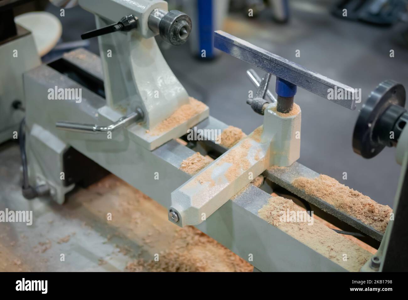 Close up view: wood turning lathe machine with shavings at workshop ...