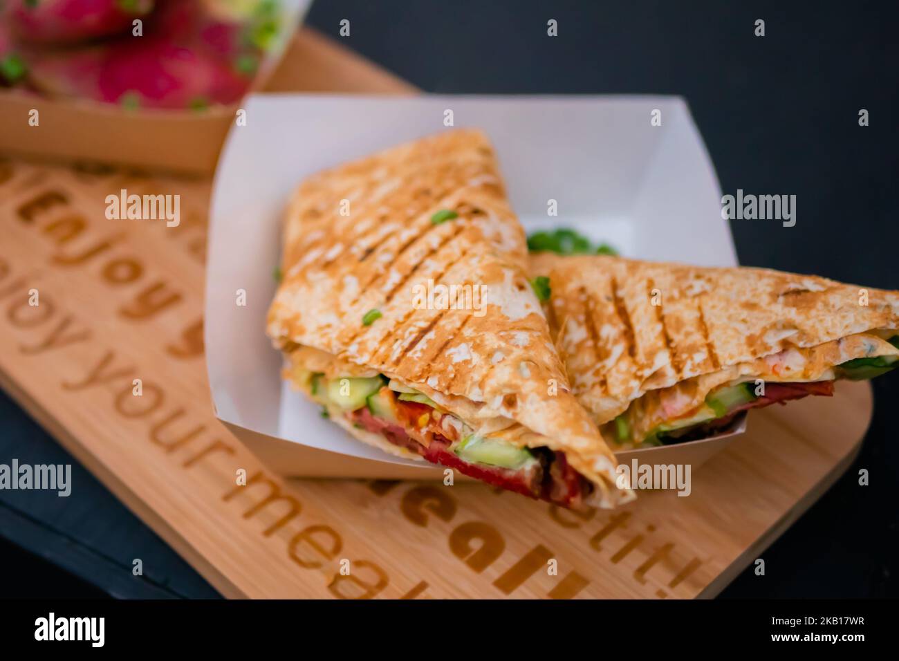 Doner kebab in paper box on wooden board at street food festival Stock ...