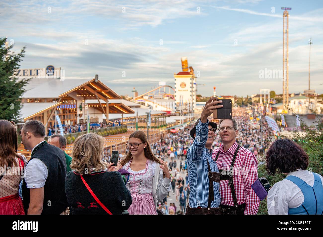 Visitors celebrate as they get their first beer mug in a beer tent at ...