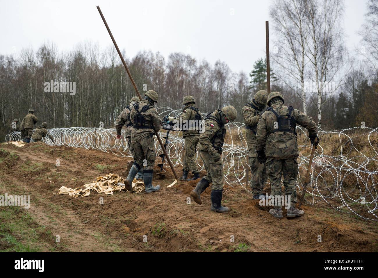 Polish soldiers are building a razor wire fence along the border with ...