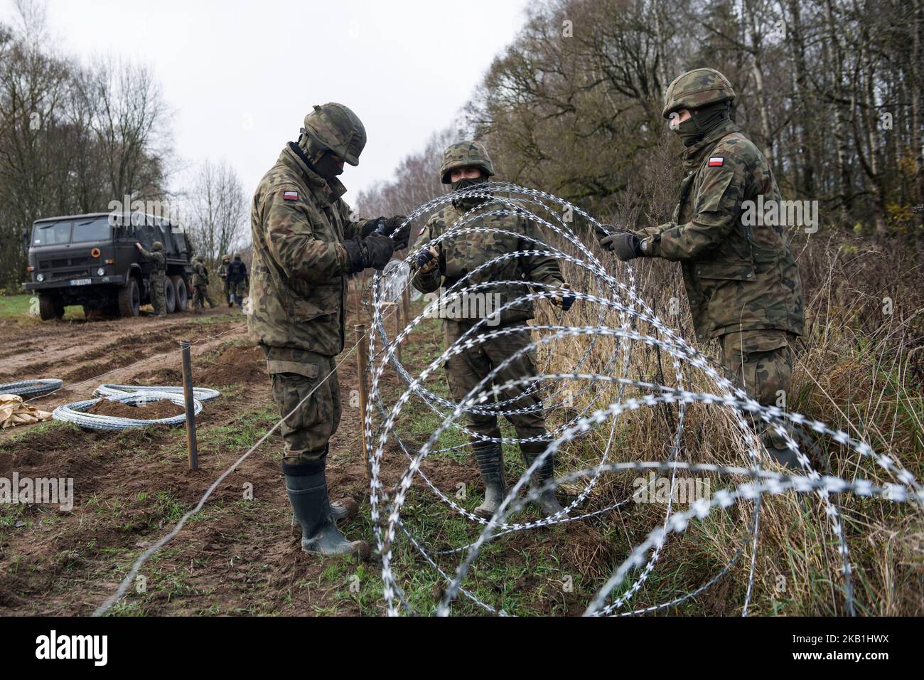 Polish soldiers are building a razor wire fence along the border with ...