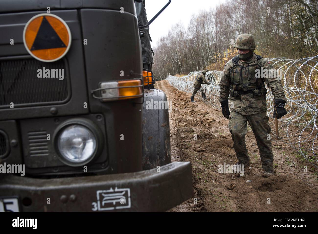 Polish soldiers are building a razor wire fence along the border with ...