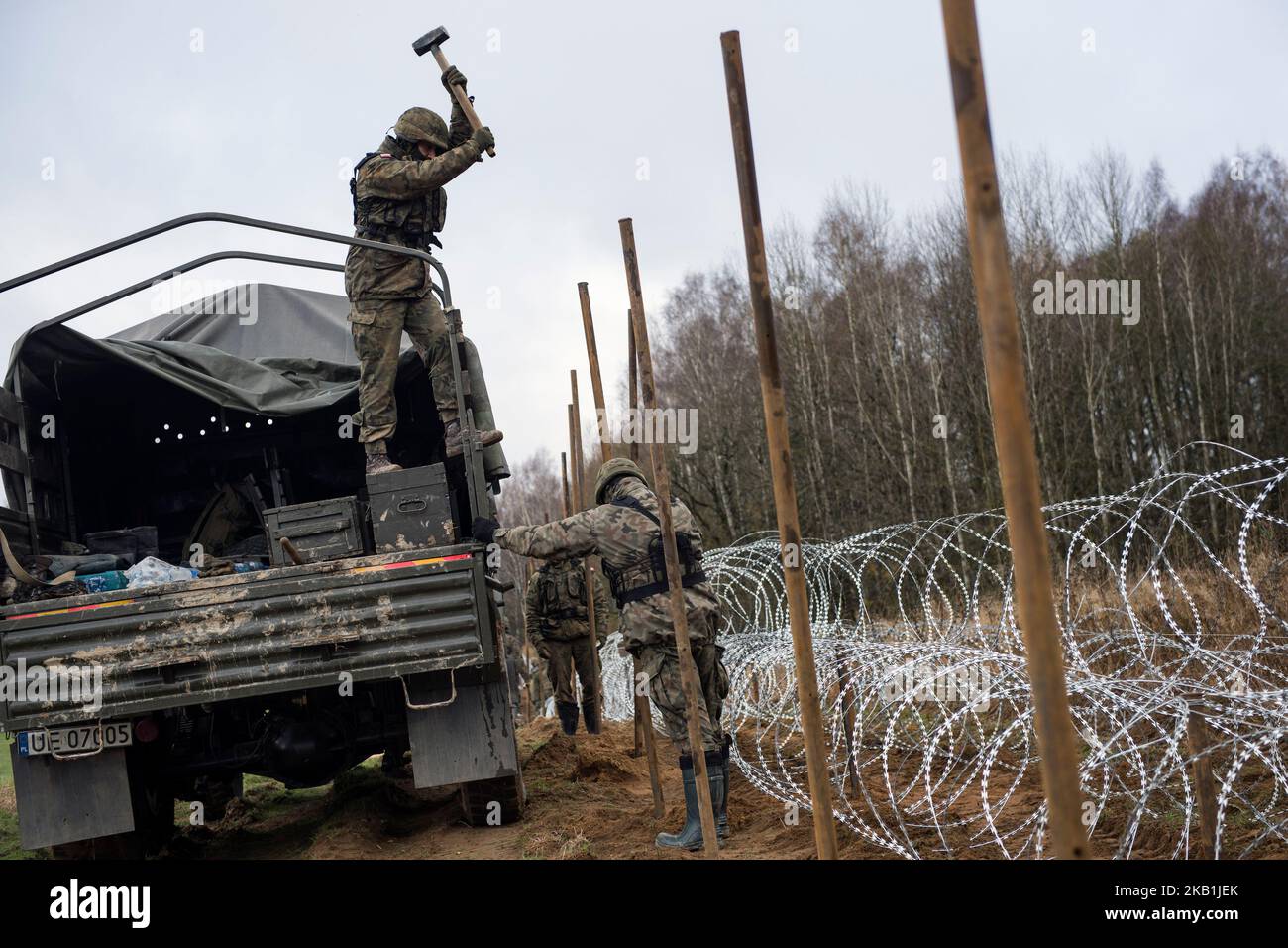 Polish soldiers are building a razor wire fence along the border with ...