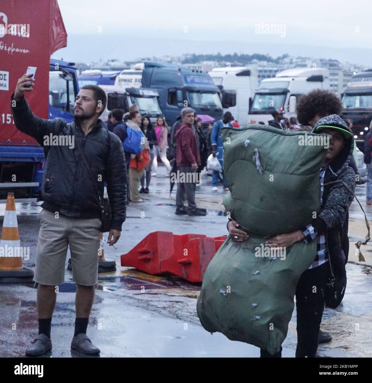 A refugee carry his belonging items after they disembark from a ferry ...