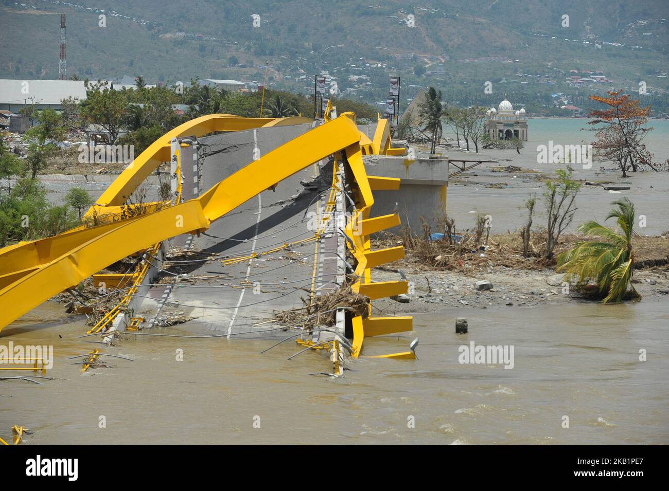 Palu residents stand near on the Palu Bridge, which collapsed in the ...