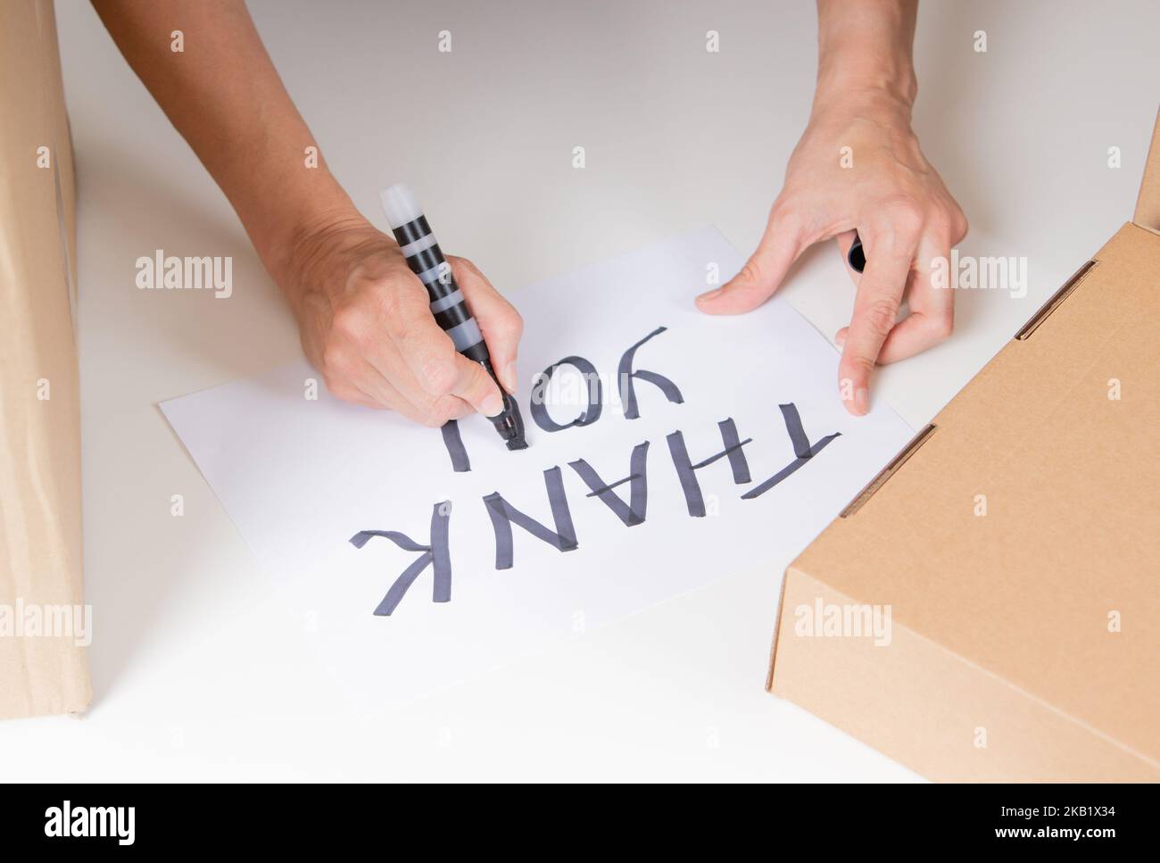 Woman hand with black marker writing Thank You on white paper. Donation ...