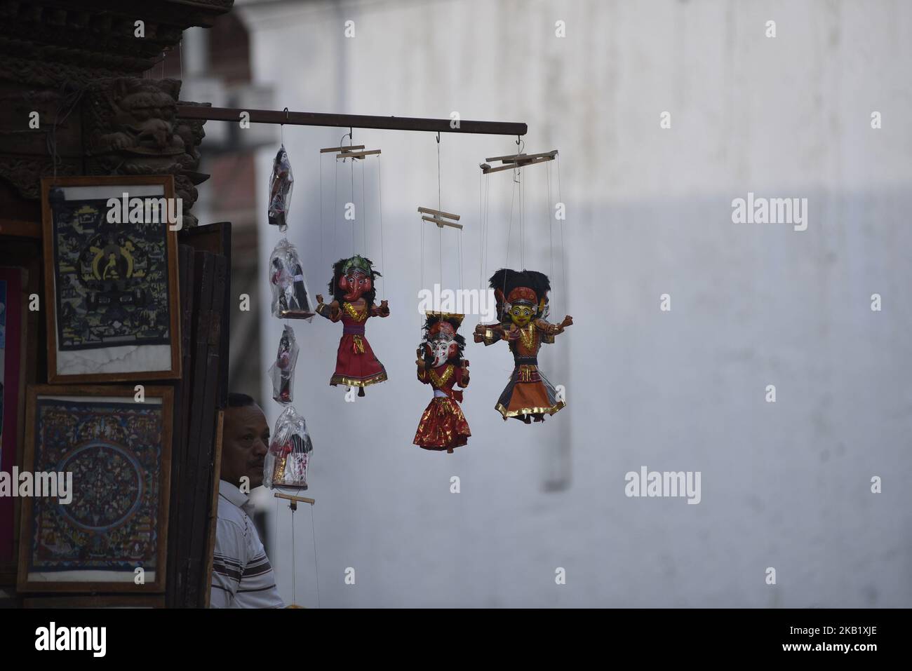 A shopkeeper stands to sell the puppet of God and Godess at the ...