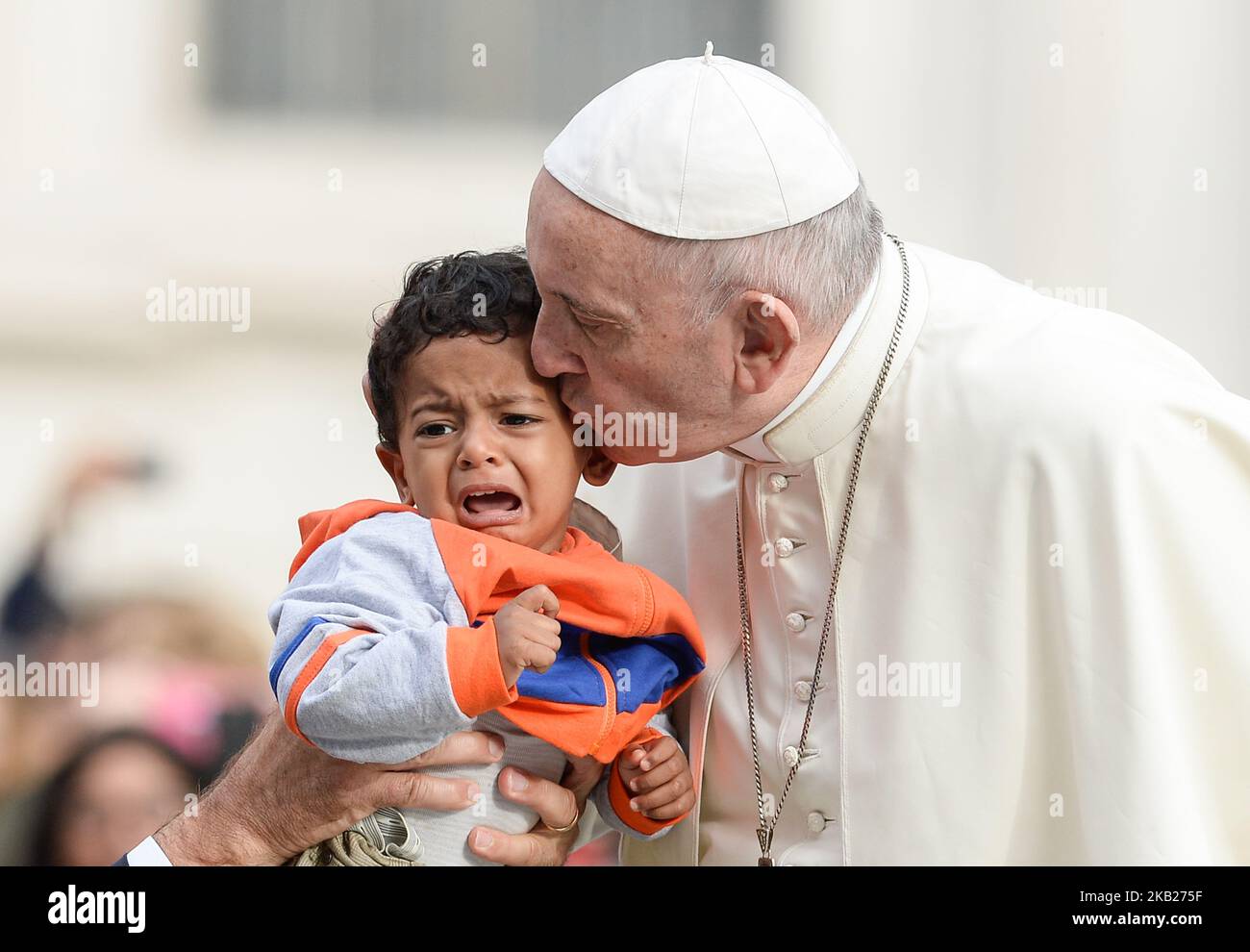 Pope Francis kisses and blesses a child during his weekly general ...