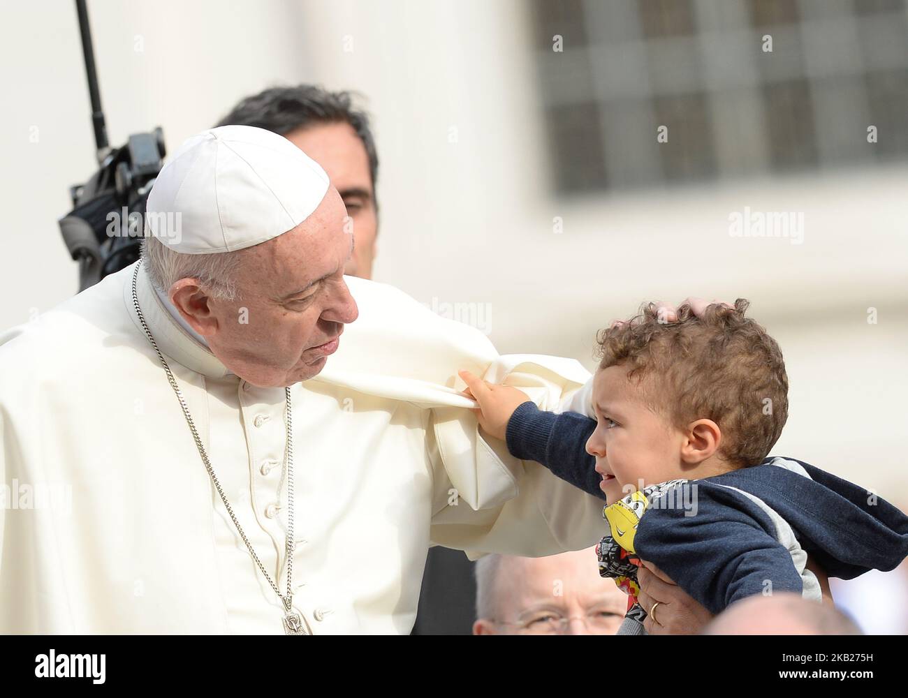 Pope Francis kisses and blesses a child during his weekly general ...