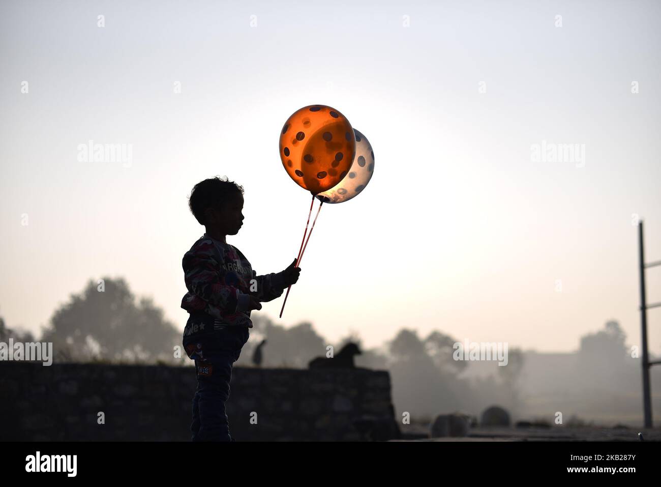 A little kid carrying air ballons during the tenth day of Dashain Durga ...