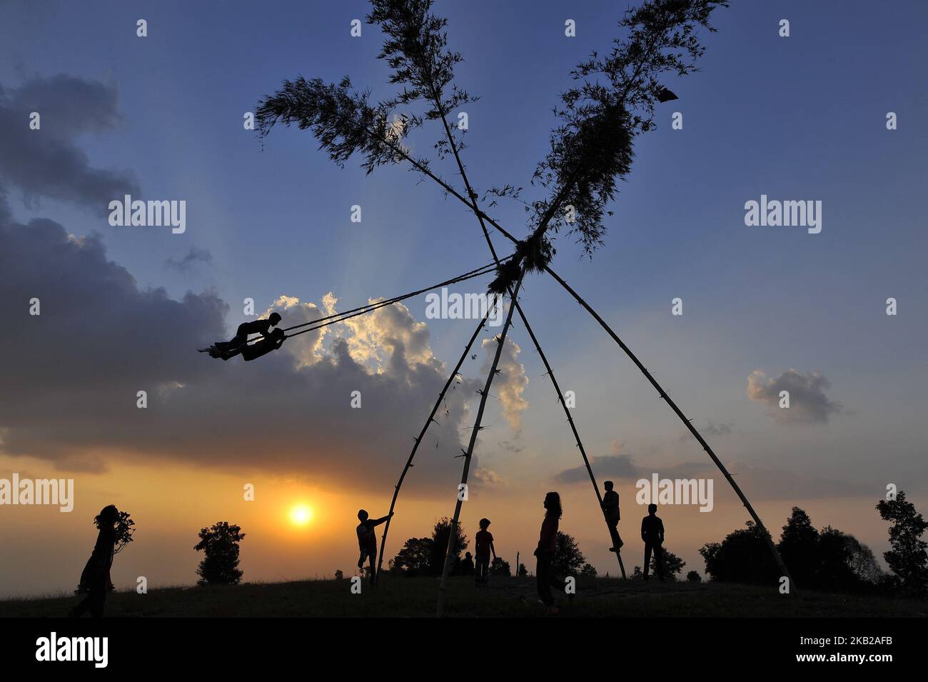 Boys play on a traditional bamboo ping or swing during Dashain festival ...