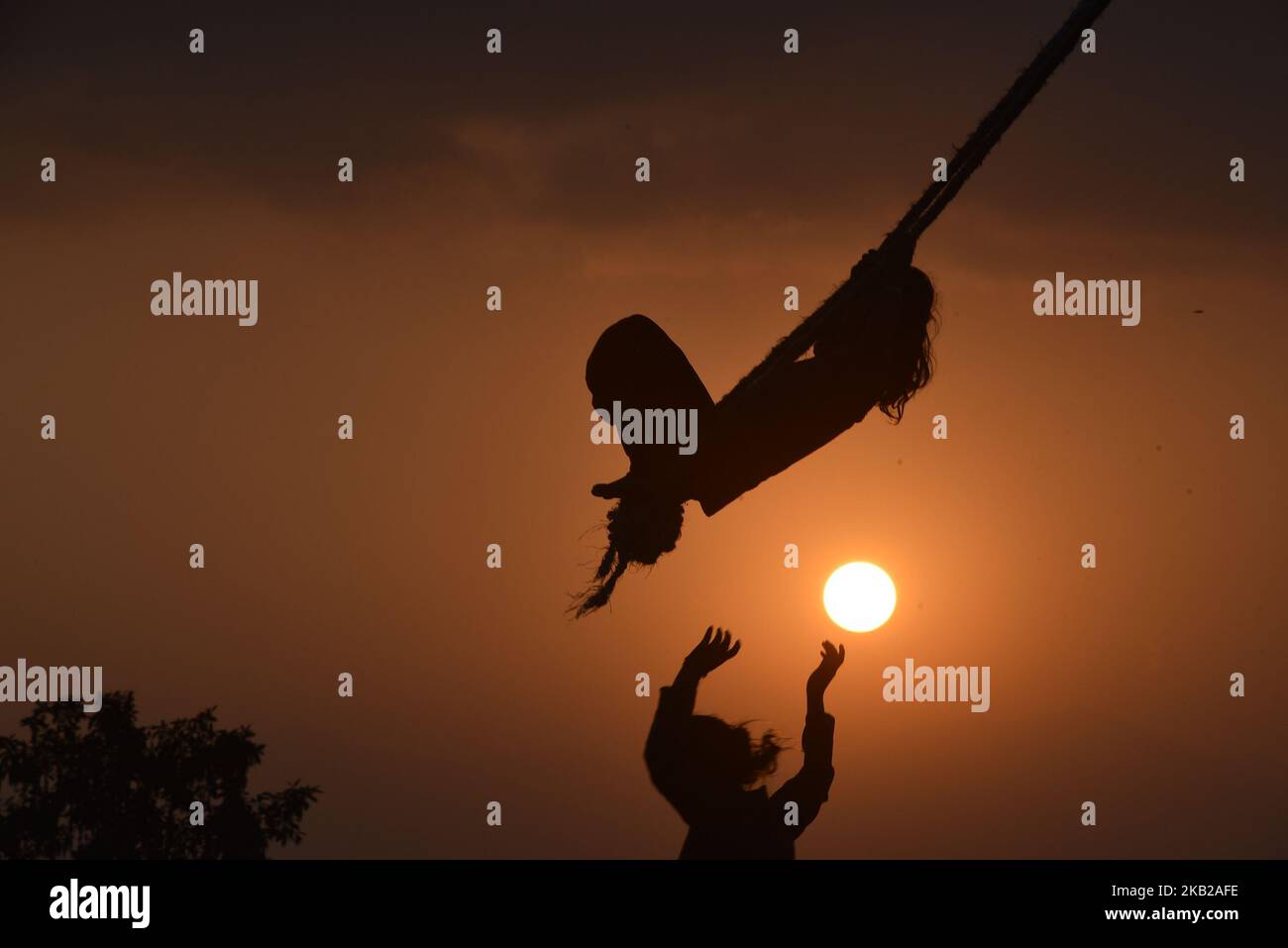 A girl plays on a traditional bamboo ping or swing during Dashain ...