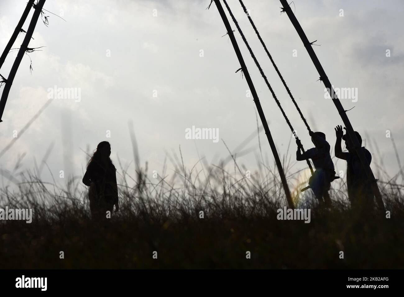 Nepalese girls play on a traditional bamboo ping or swing during ...