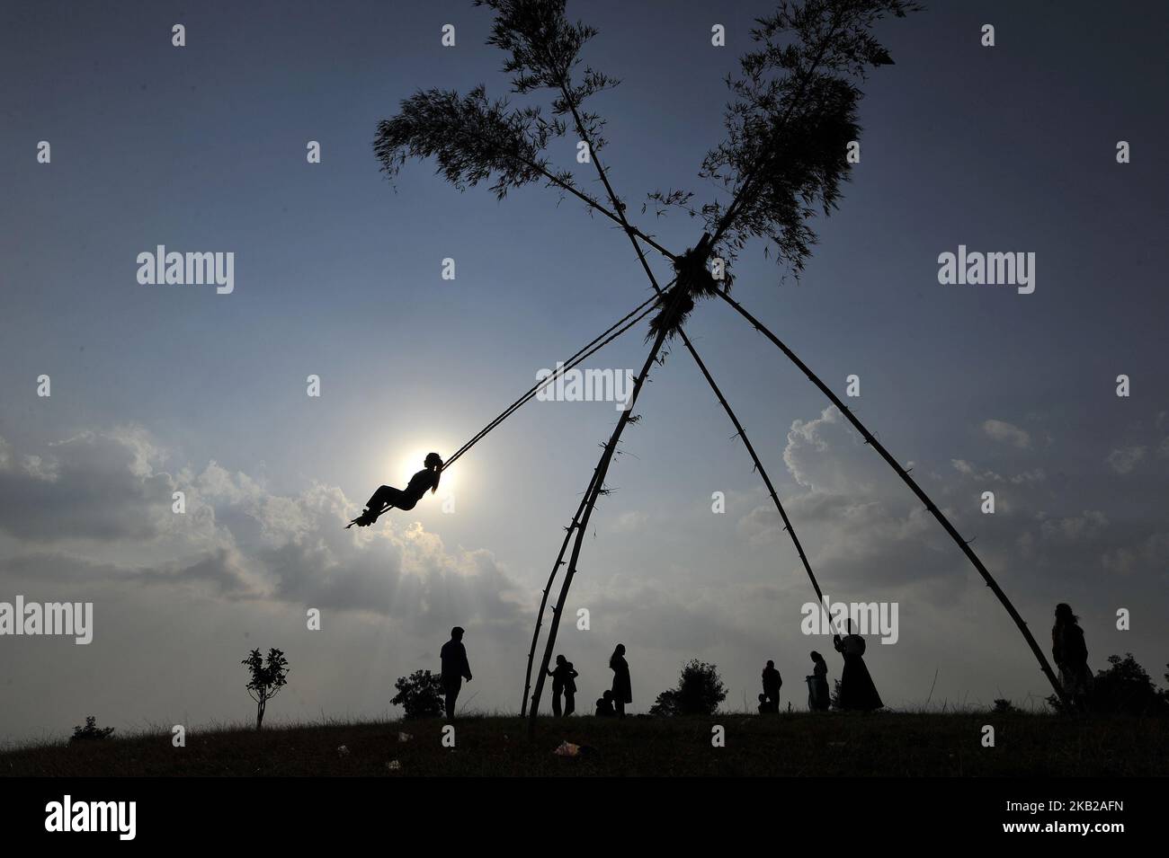 Nepalese girls play on a traditional bamboo ping or swing during ...