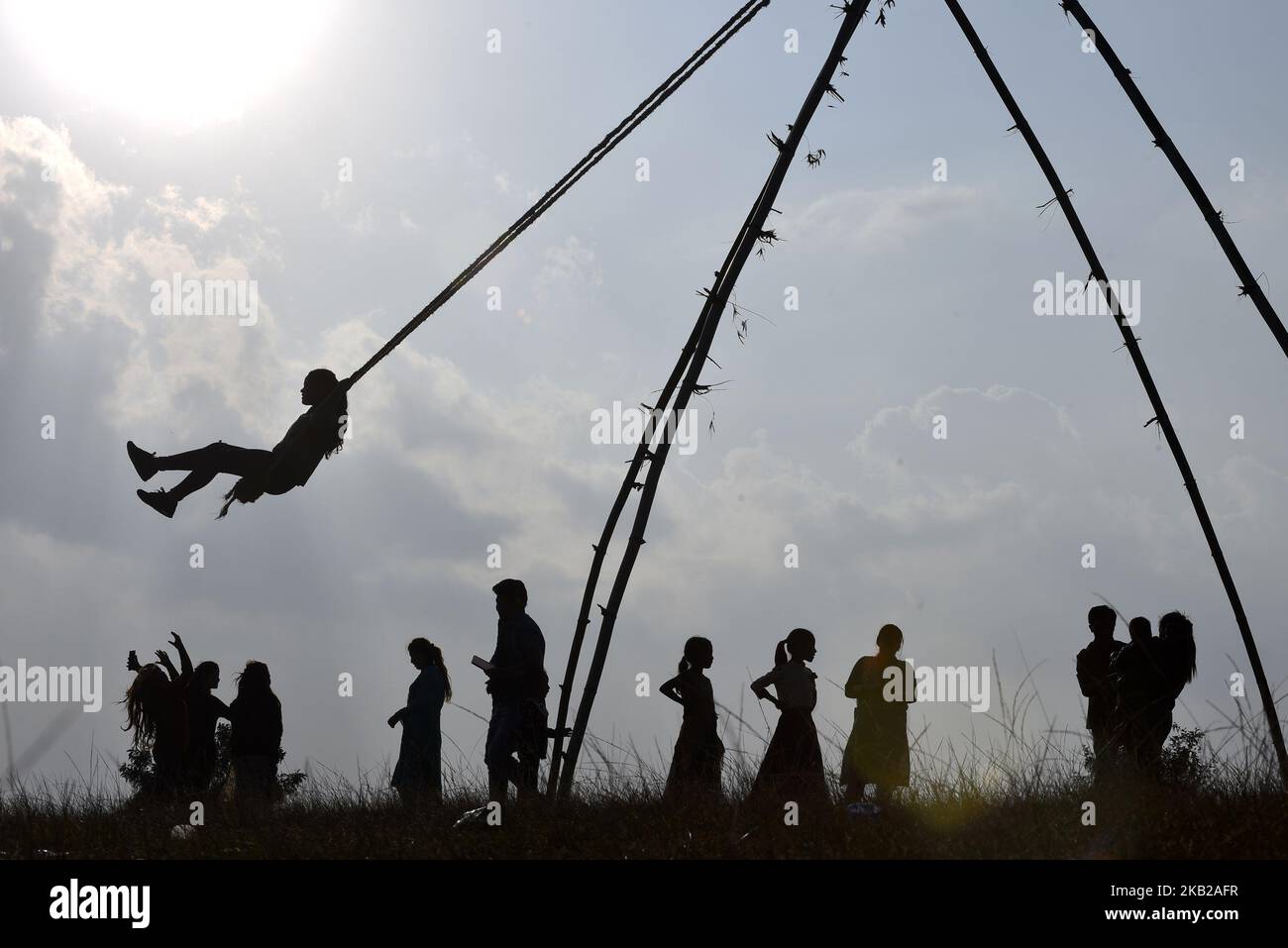 Nepalese girls play on a traditional bamboo ping or swing during ...