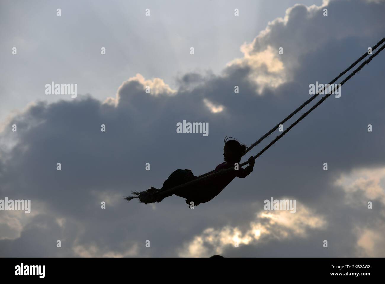 A girl plays on a traditional bamboo ping or swing during Dashain ...