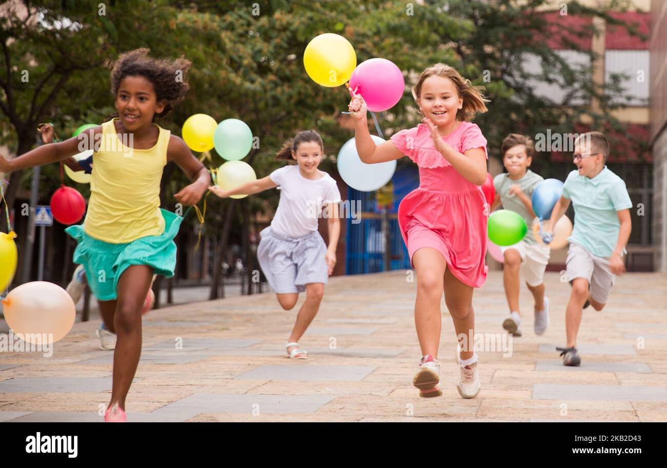 Children with balloons running through city streets Stock Photo - Alamy