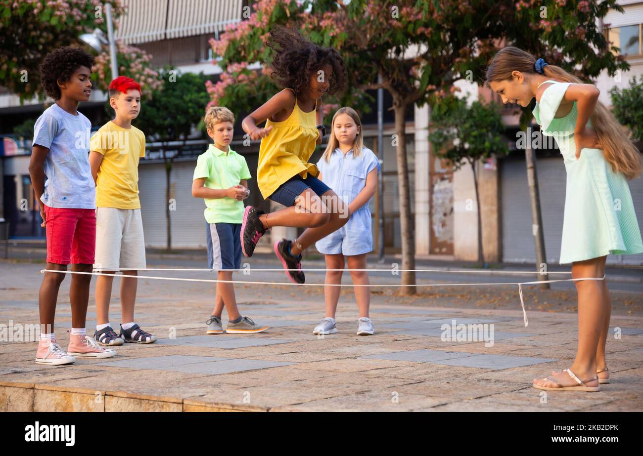 Children playing with jumping rope outdoors Stock Photo - Alamy