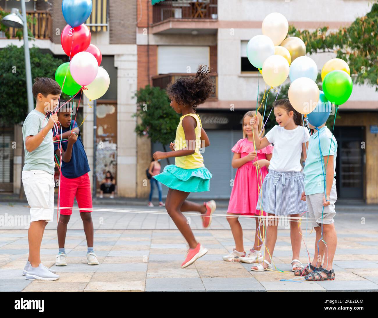 Kids playing with Chinese jumping rope outdoors Stock Photo - Alamy