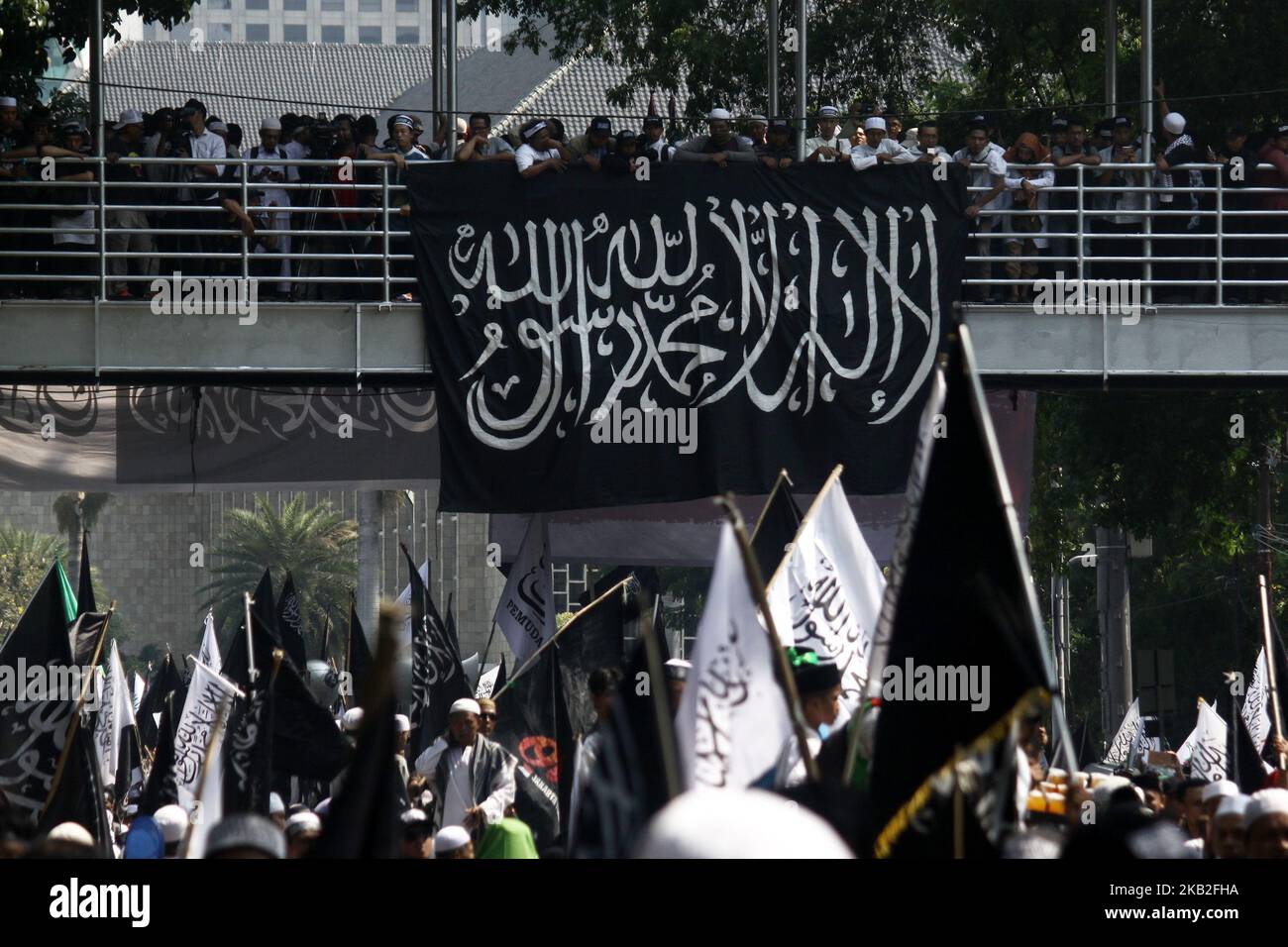 Indonesian Muslims carrying Tawheed flags and other attributes staged ...