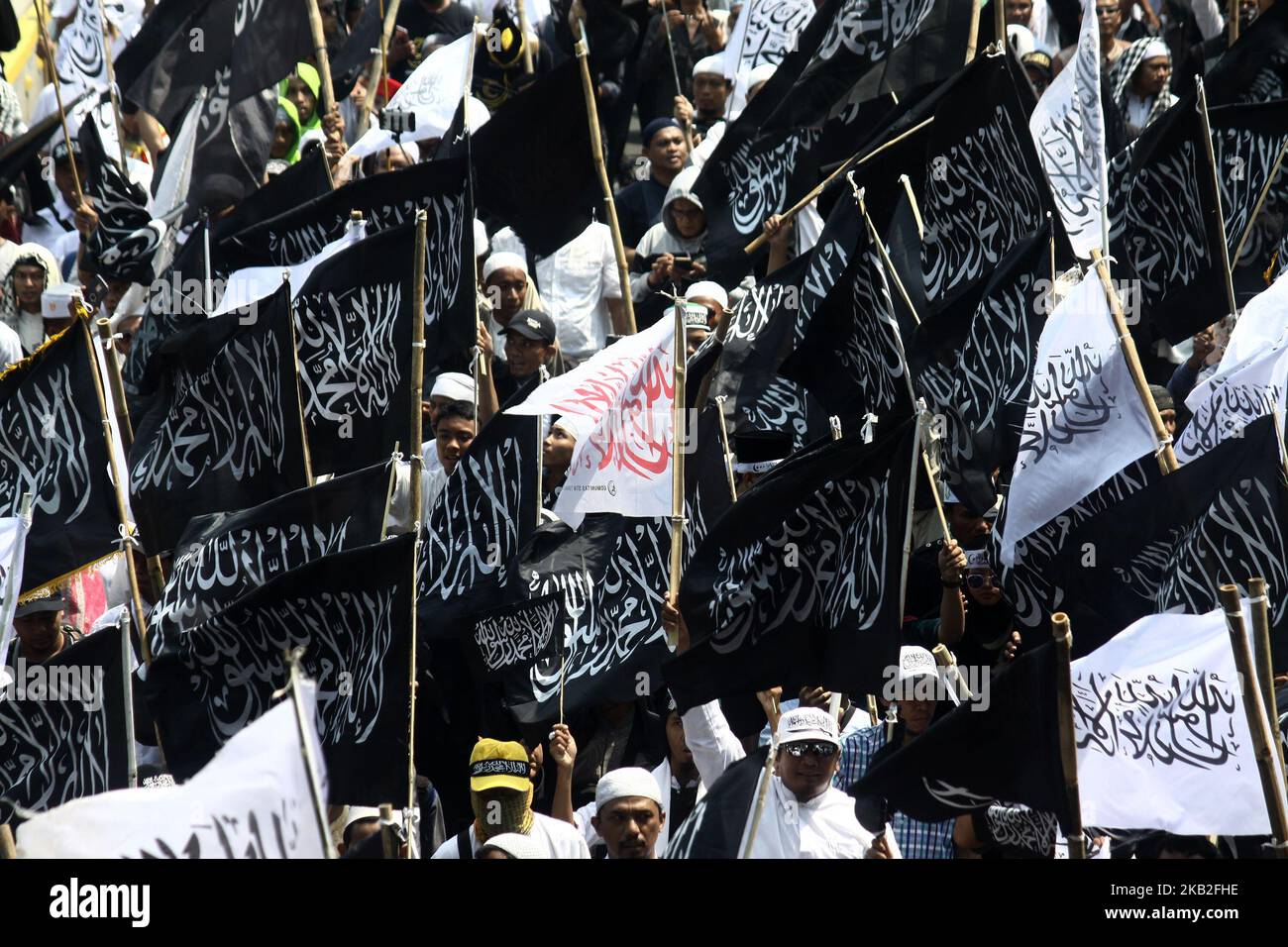 Indonesian Muslims carrying Tawheed flags and other attributes staged ...
