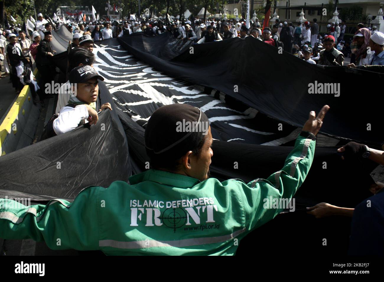 Indonesian Muslims carrying Tawheed flags and other attributes staged ...