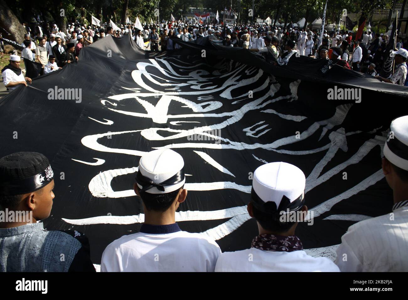 Indonesian Muslims carrying Tawheed flags and other attributes staged ...