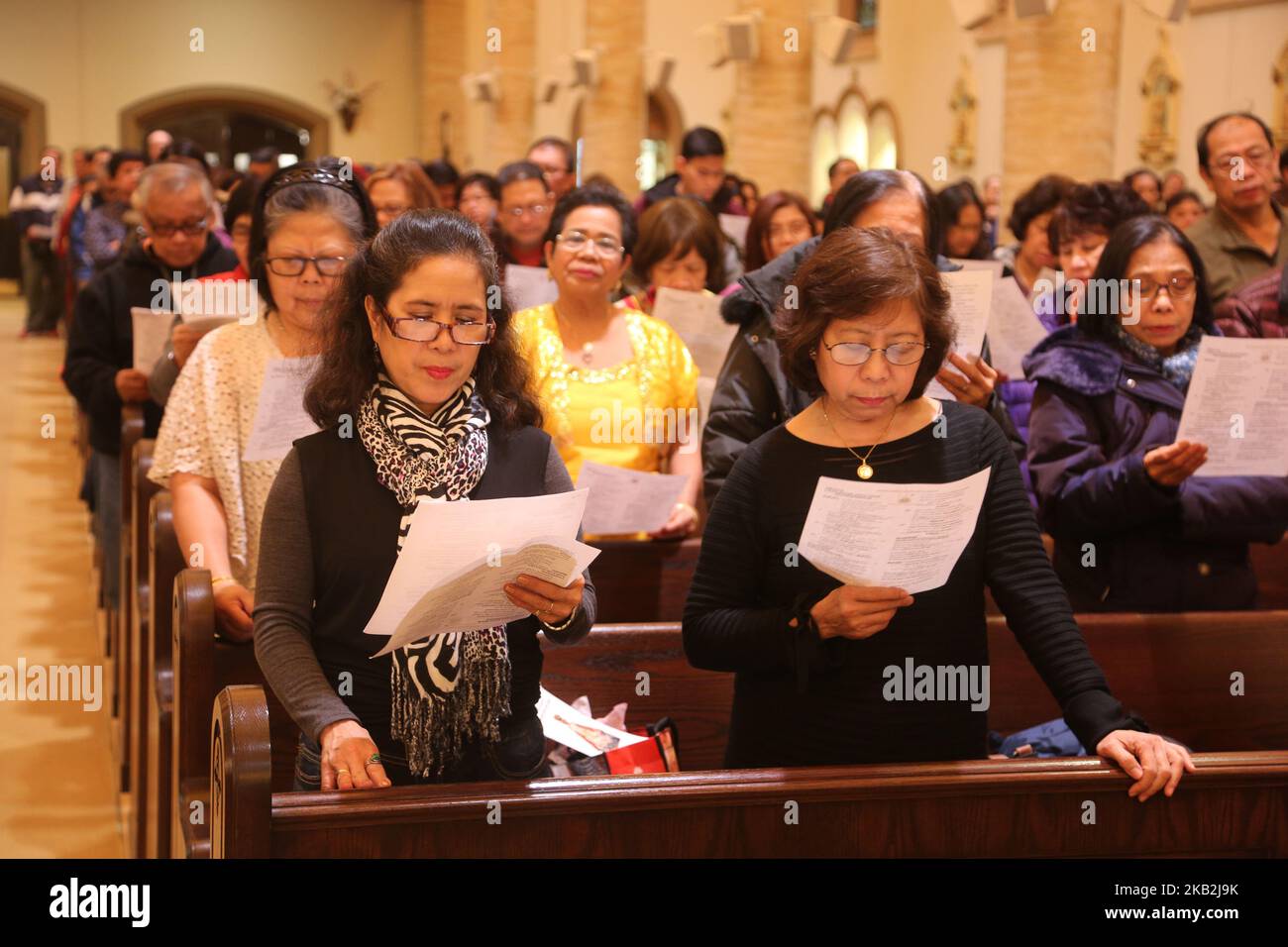 Filipino Catholics sing hymns during a special mass celebrating the ...