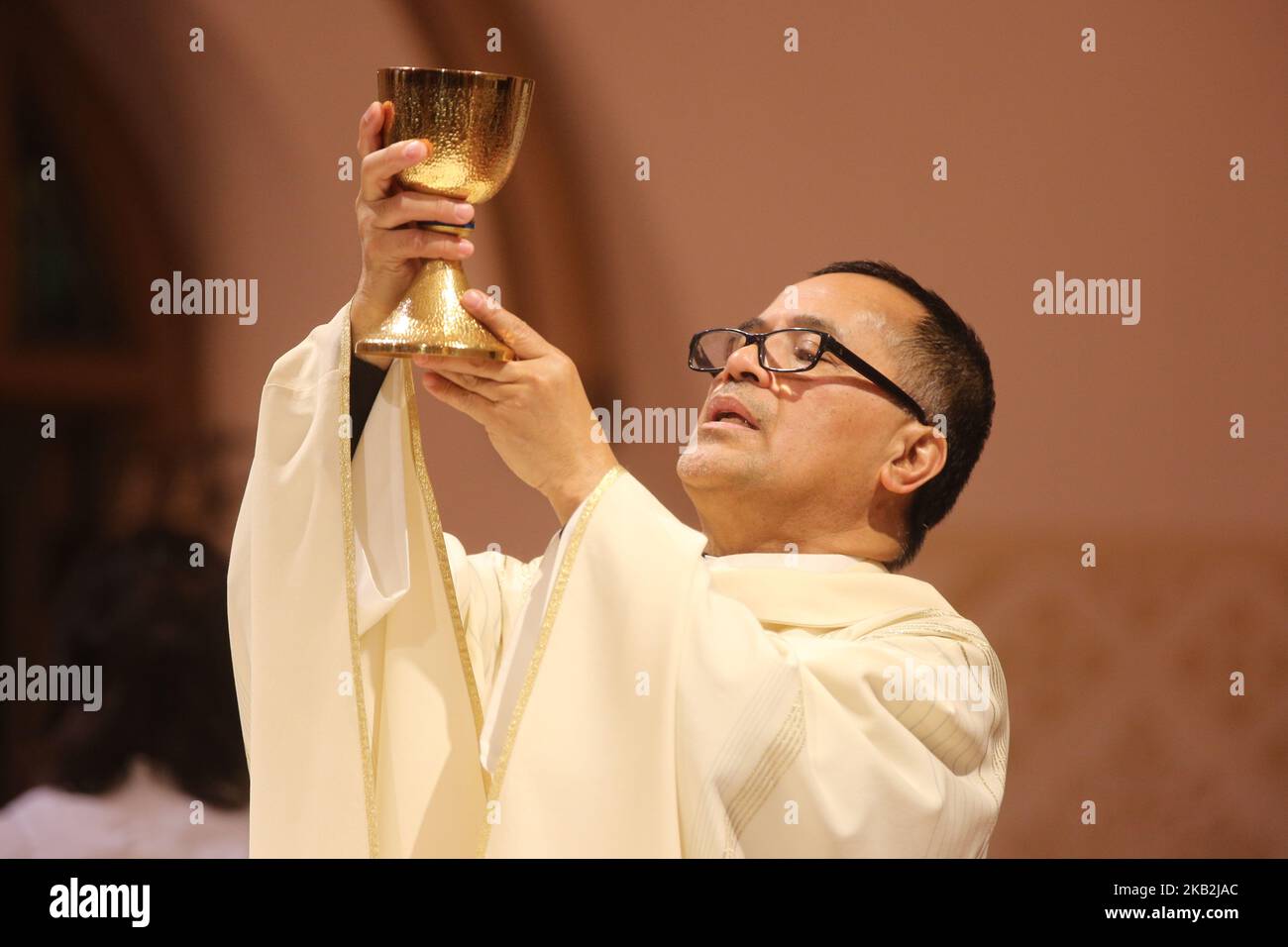 Filipino Catholic priest performs communion during a special mass ...