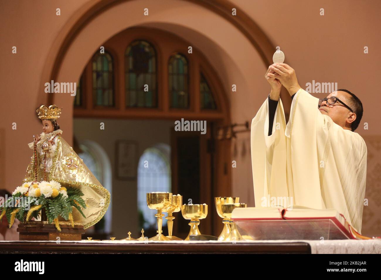 Filipino Catholic priest performs communion during a special mass ...
