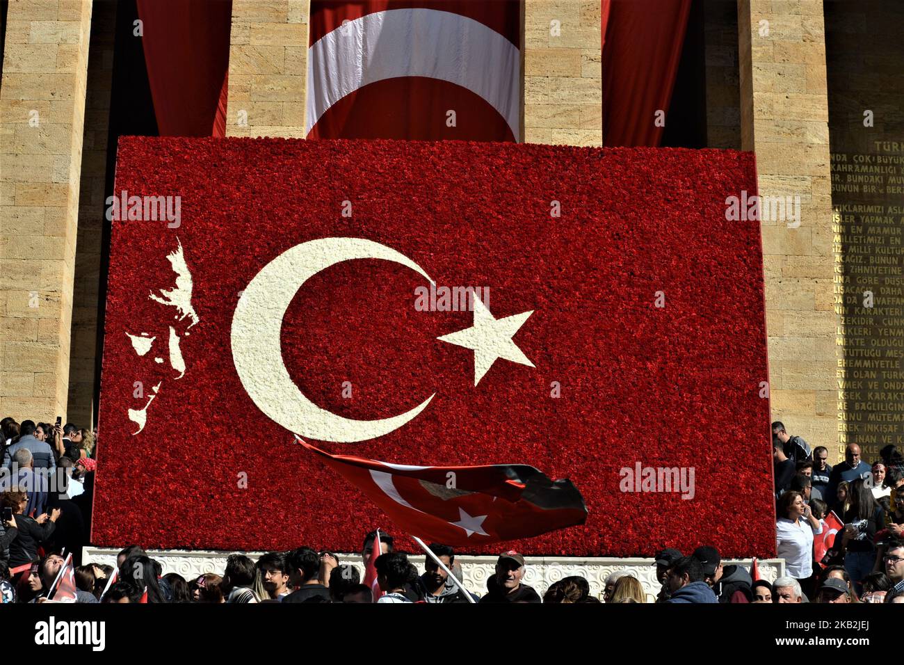 A visitor waves the Turkish national flag in front of a board in the ...
