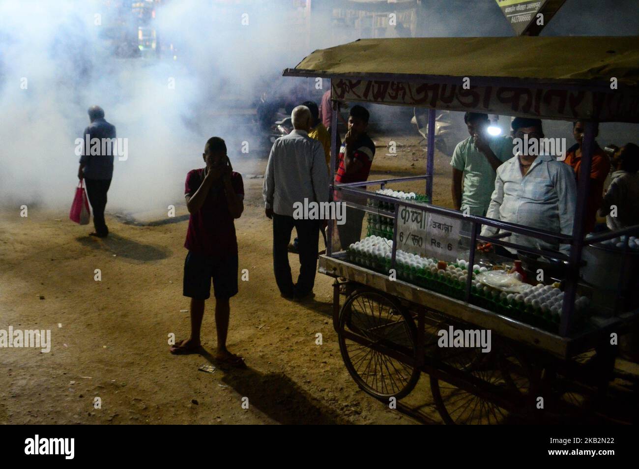 An indian local vendor sells roadside food during smoke from fumigation ...