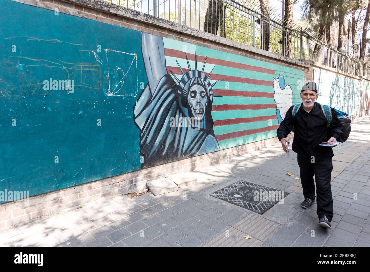 A man walks in front of anti-American revolutionary graffiti on ...