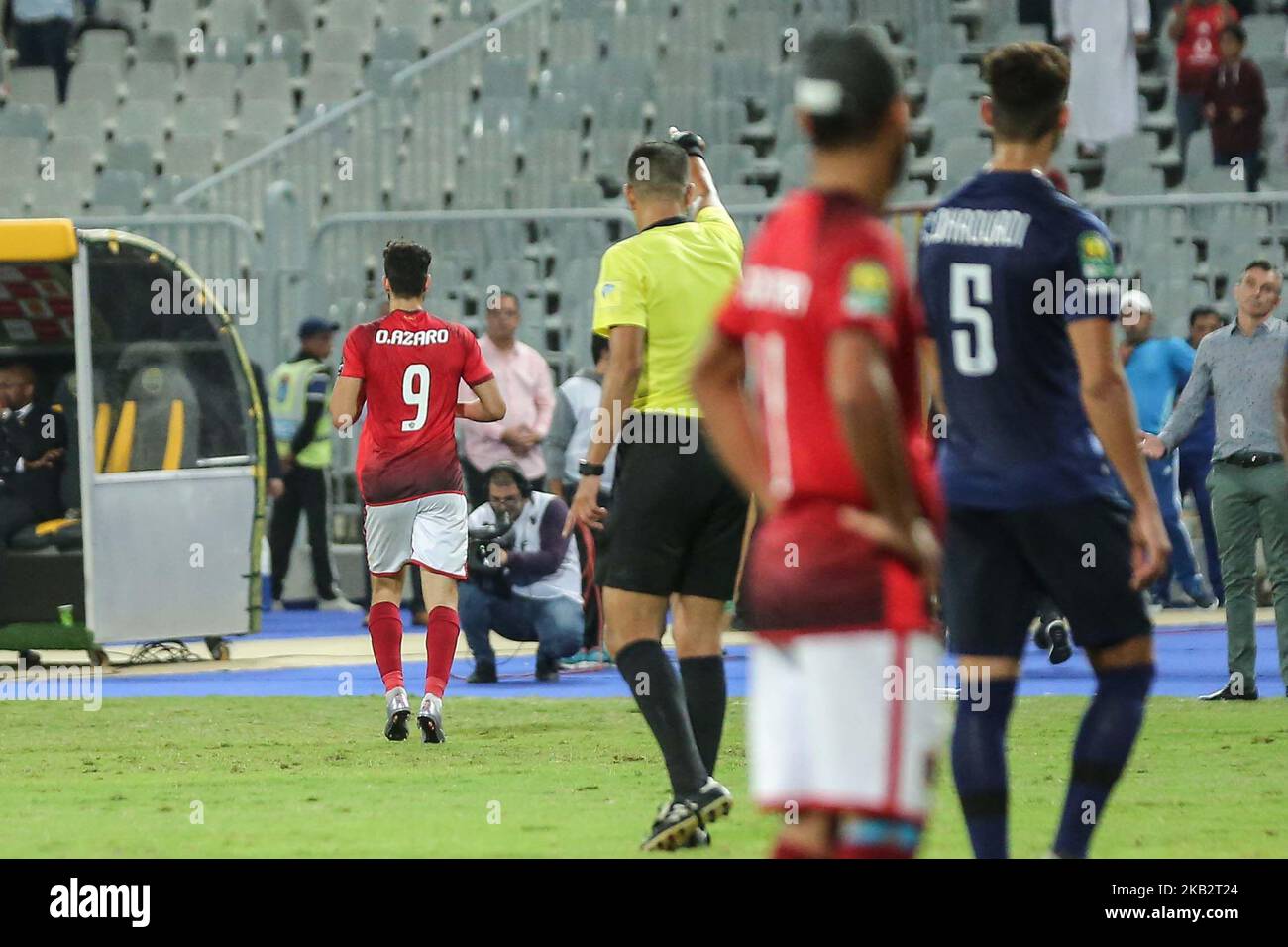 Ahly's Walid Azaro (C) seen with his torn jersey as he walks out to ...
