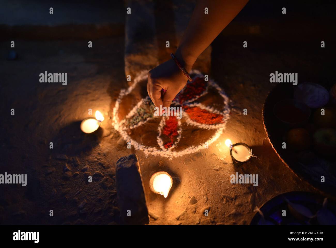 A Nepalese devotee offering ritual prayer infront of home during Laxmi ...