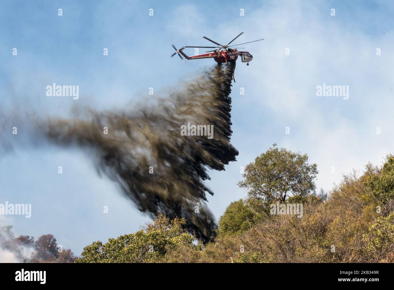 A helicopter makes a water drop on the Woolsey Fire near Malibu ...