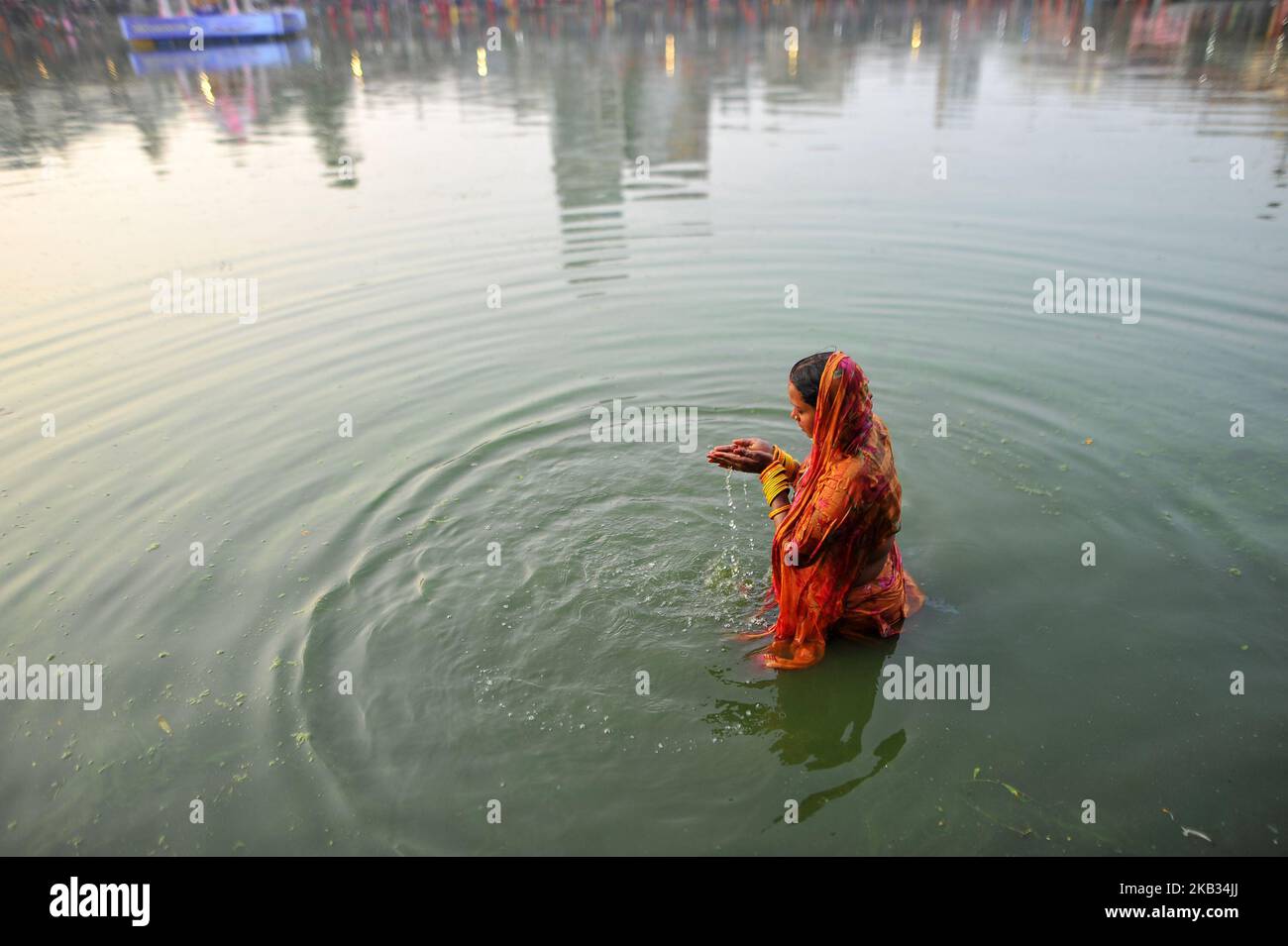 A Nepalese Devotee takes holy bath before offering rituals to the sun ...