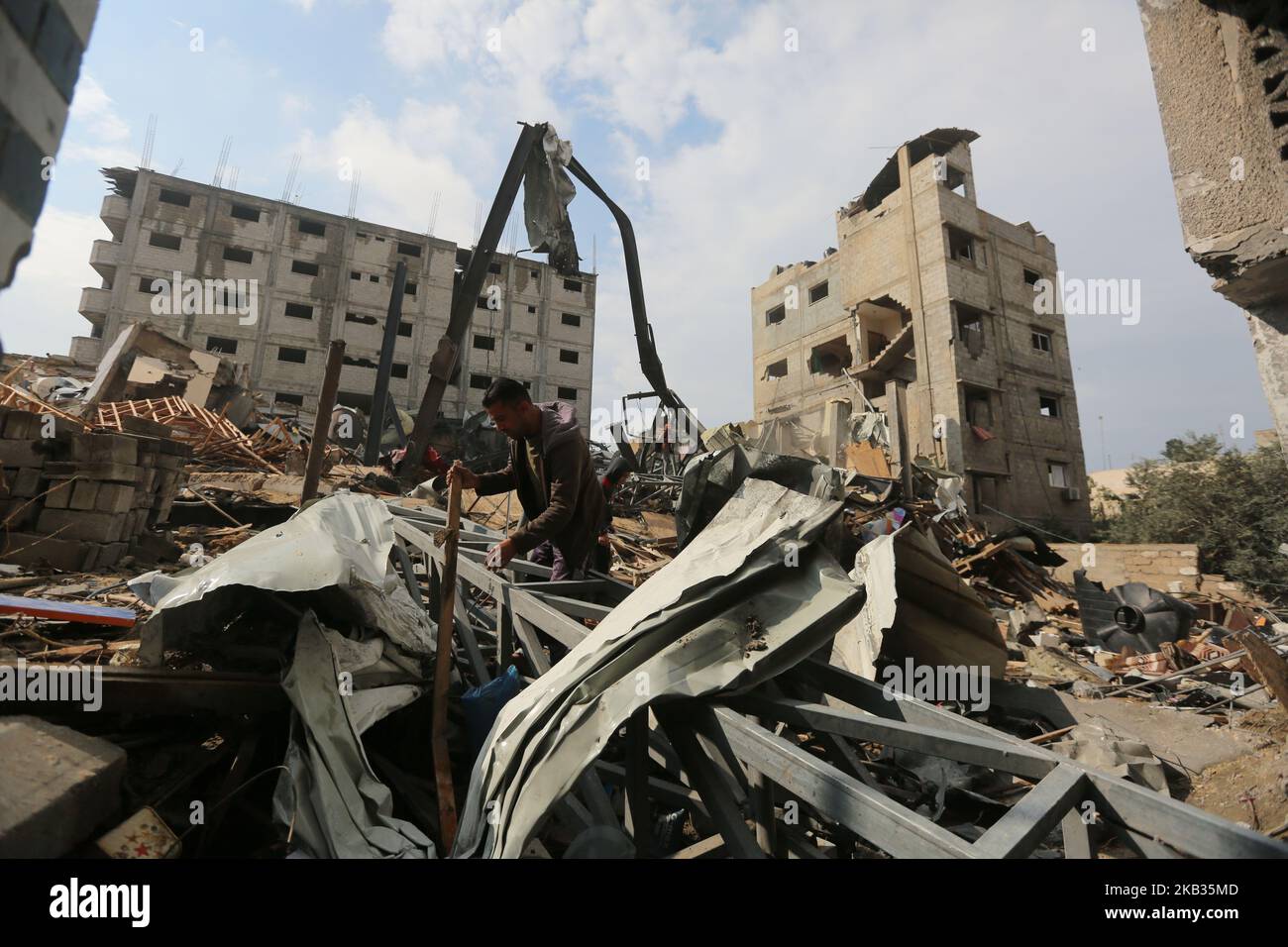 A Palestinian stands amidst the rubble of the building housing the ...