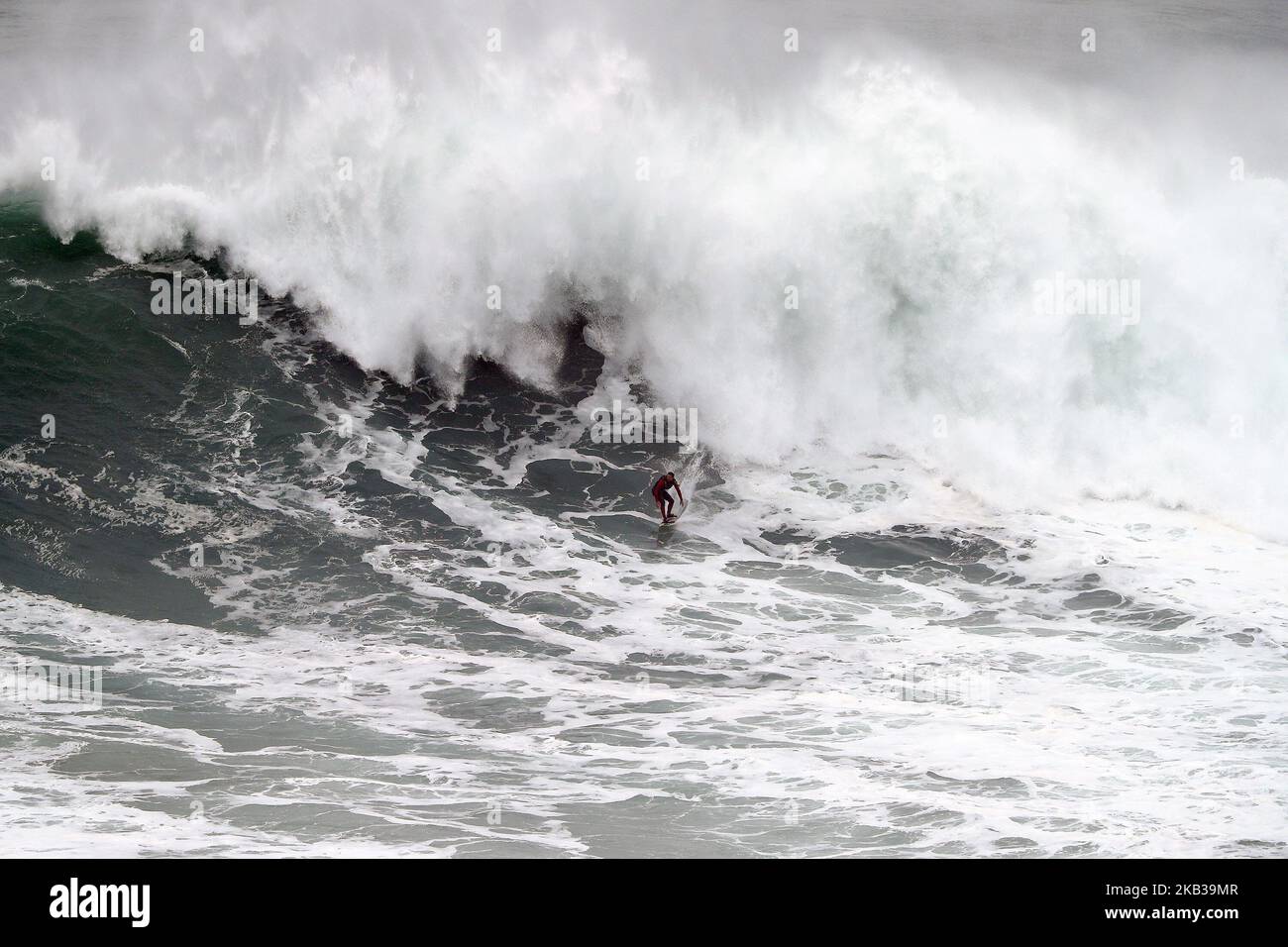 A big wave surfer drops a wave during a tow-in surf session at Praia do ...