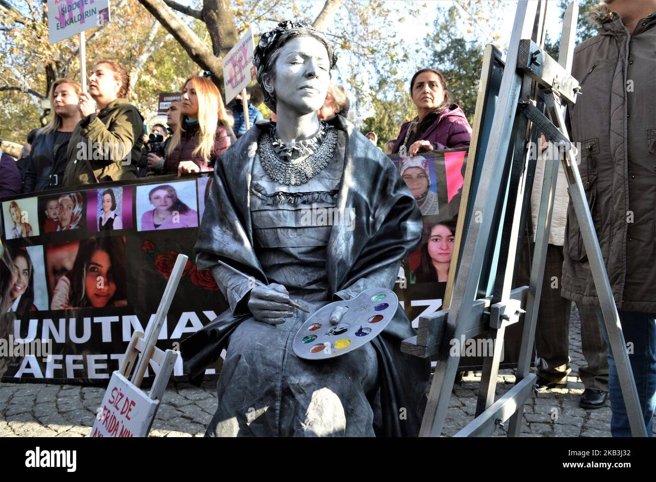 A female artist painted herself in gray performs a mime performance ...