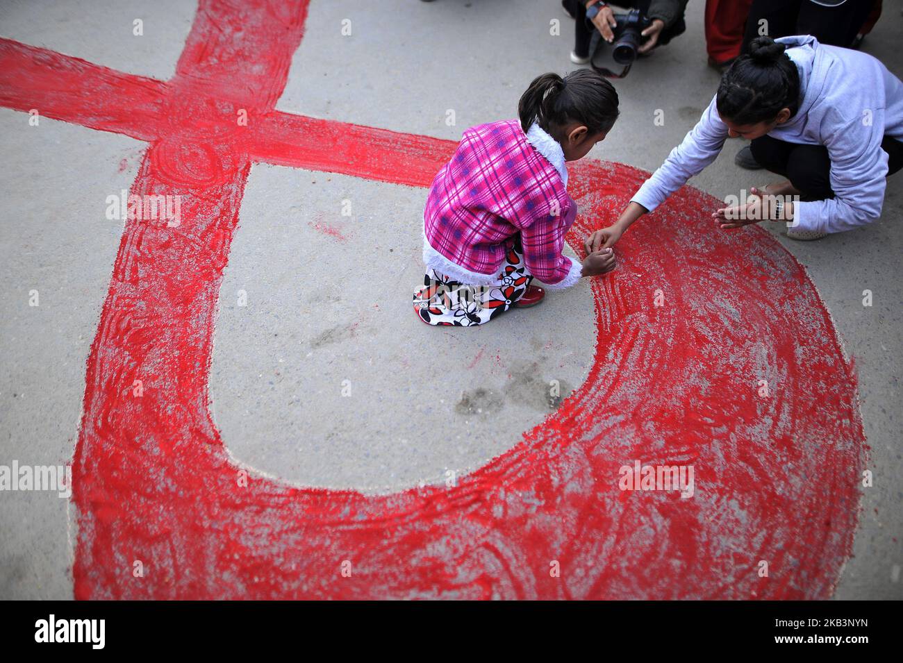 A little girl lit candles around the symbol of RED AIDS during Eve of ...