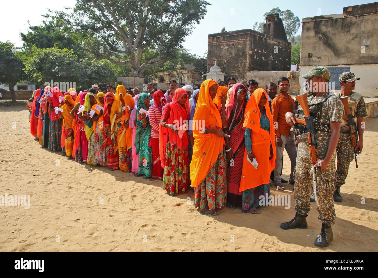 Indian women stand in queue to cast their vote at a local polling ...