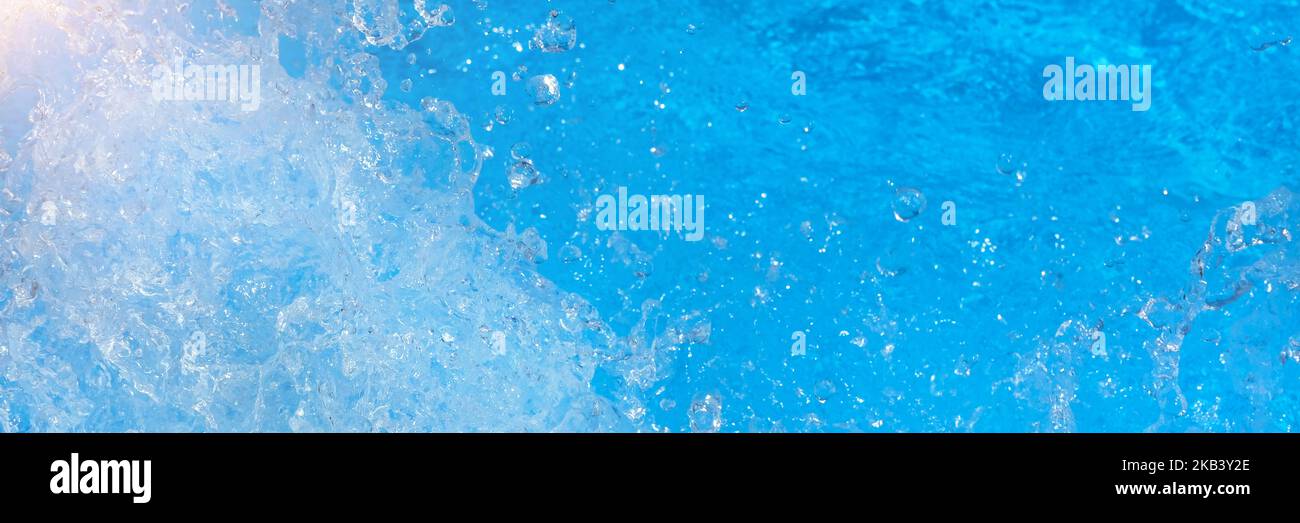 Surface of blue swimming pool water with light reflection, splashes and ...