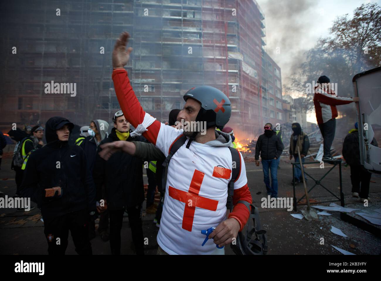 A Yellow Vest paramedic guides firefighters throught the crowd and the ...