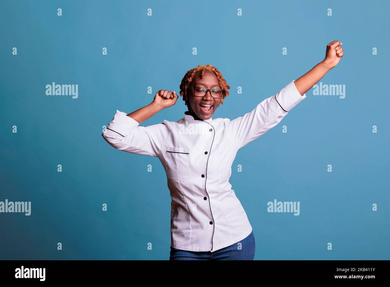 Laughing haired cooker in uniform celebrating, partying happily. Self ...