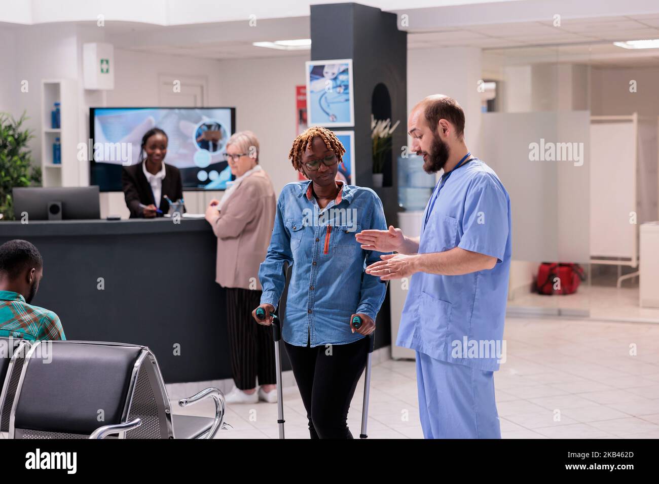 Hospital administrative staff guiding african american patient with ...