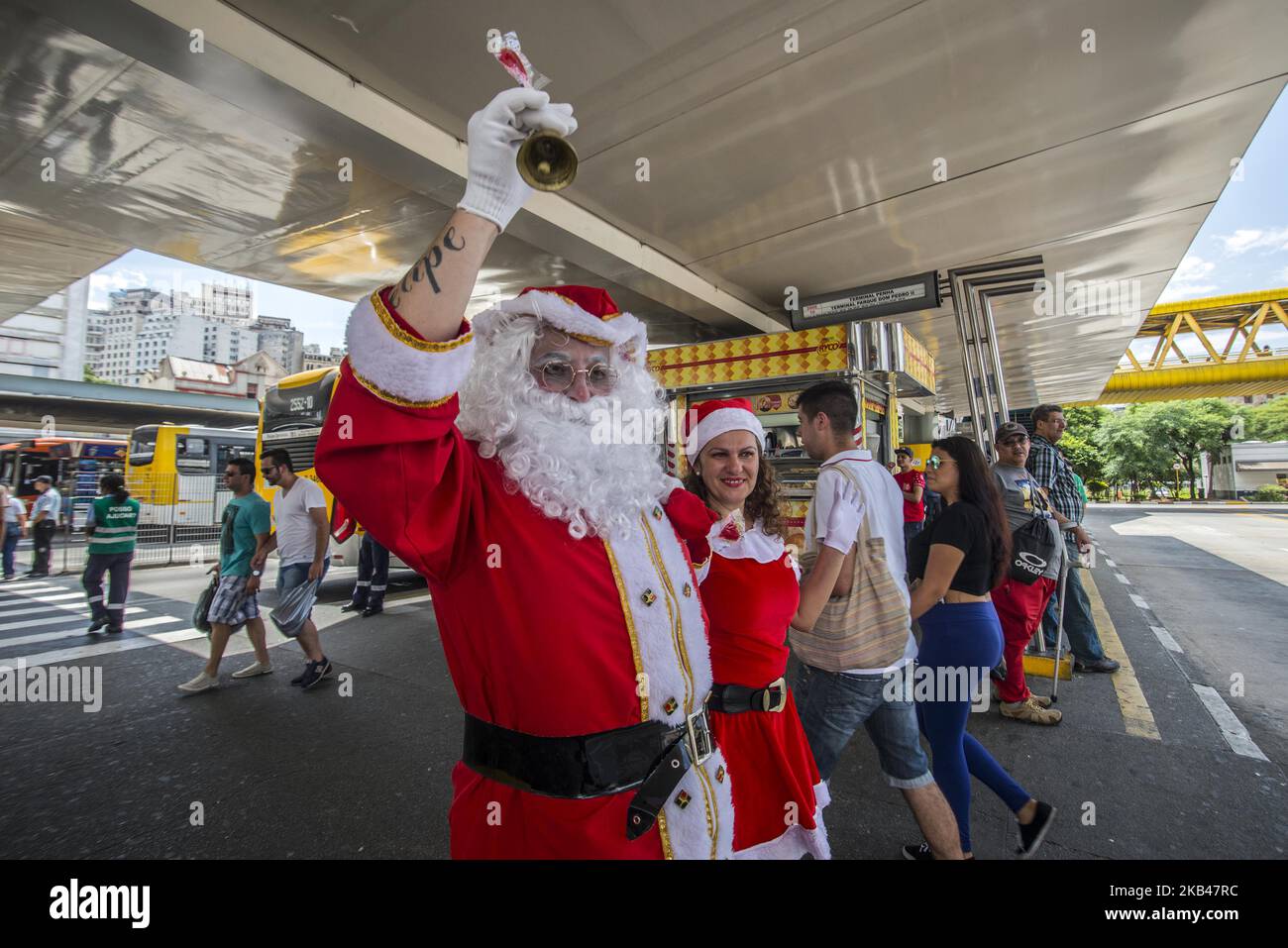 Santa Claus and Mama Claus entertain passengers at a bus terminal in ...